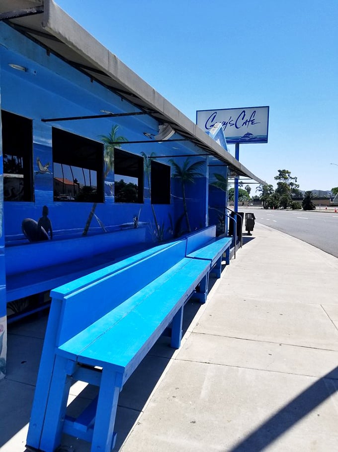The waiting area where anticipation builds like the perfect wave. Those blue benches have heard countless breakfast dreams.