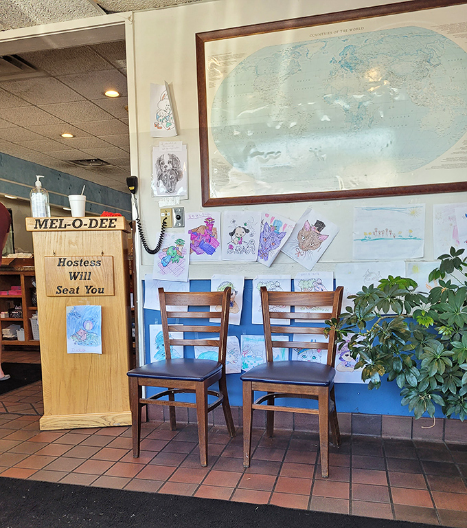 "Hostess Will Seat You" sign and children's artwork—small touches that transform a restaurant into a community gathering place.
