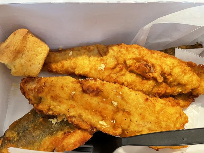 Fish that's been given the royal treatment—crispy exterior giving way to flaky perfection. The cornbread sidekick isn't just moral support.