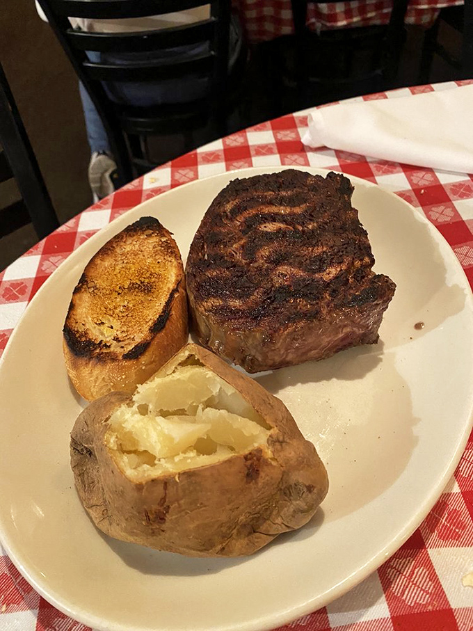 The star of the show in all its glory—a thick-cut ribeye with perfect grill marks that whisper, "This is why you drove all this way."