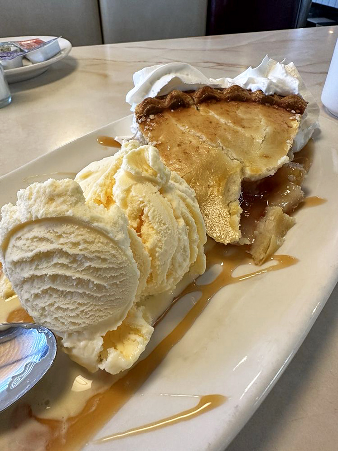 Apple pie à la mode: the dessert equivalent of a warm hug. That caramel drizzle isn't just decoration—it's the golden thread connecting you to generations of sweet-toothed Americans.