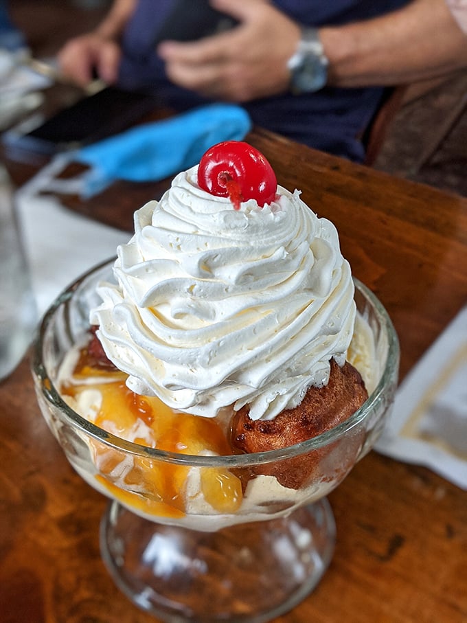 This isn't just dessert – it's architecture. A fritter foundation supporting caramel, ice cream, and whipped cream, crowned with a cherry that's just there to make other desserts jealous.
