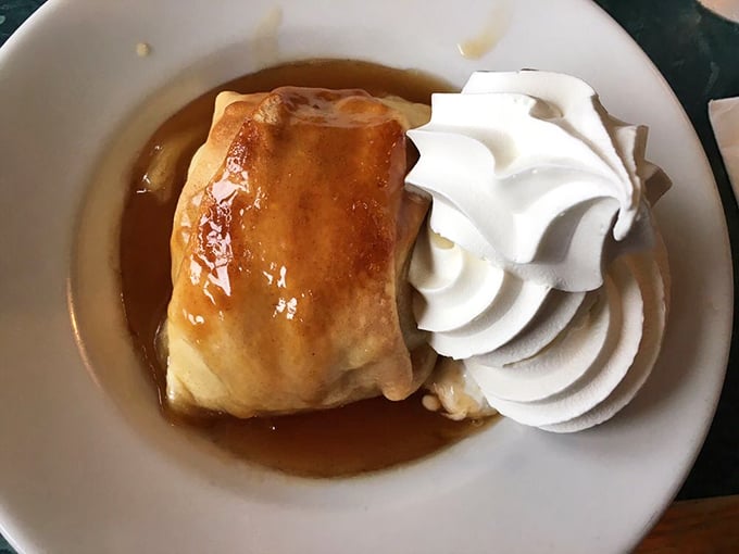 The legendary apple dumpling in all its glory. That pastry hasn't just been baked—it's been loved, and that whipped cream crown is well-deserved royalty.