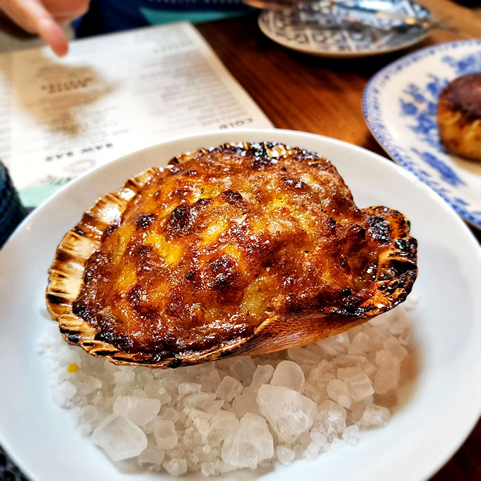 A perfectly caramelized scallop resting on a bed of salt crystals—nature's candy from the sea, treated with the respect it deserves.