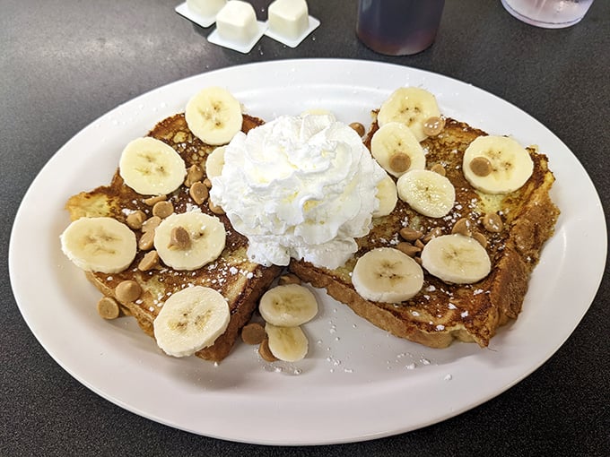 French toast that Elvis would approve of, crowned with banana slices and a cloud of whipped cream—breakfast dessert that requires no apology.