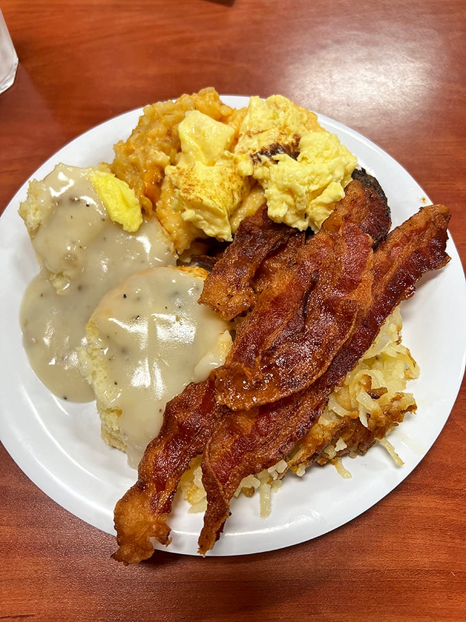 Biscuits smothered in peppery gravy alongside crispy bacon and scrambled eggs – the breakfast trinity that's converted more morning skeptics than coffee itself.
