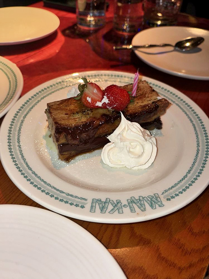 This isn't just dessert—it's bread pudding that's having its glamour shot moment, complete with whipped cream, fresh berries, and a tiny candle celebration.