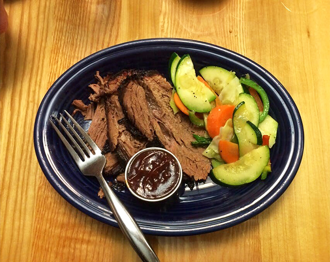 Slices of pink-centered brisket with a side of fresh vegetables—a plate that whispers "I've been smoking all day" with pride.