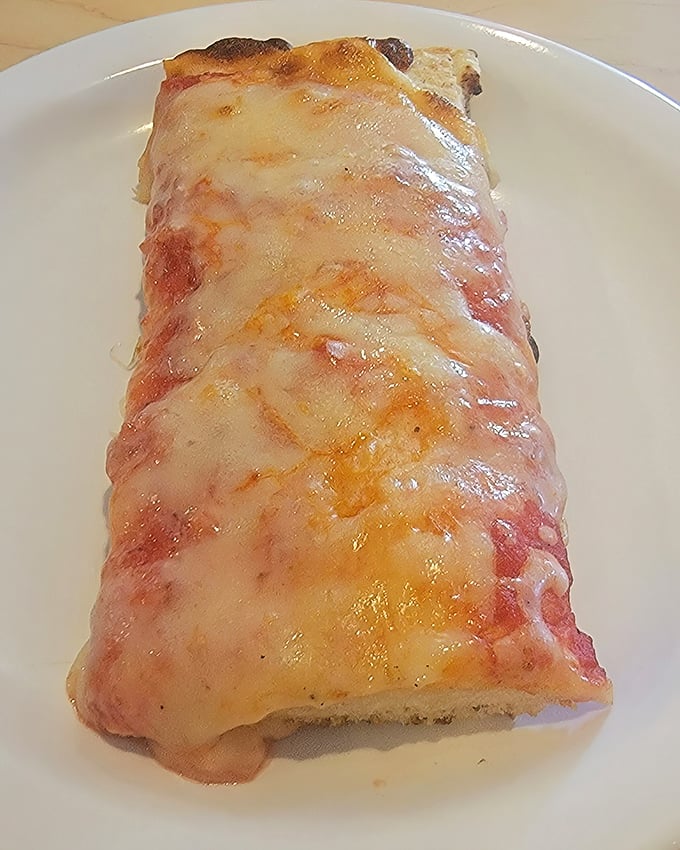 This close-up of a single cheese cut reveals the truth—Old Forge pizza isn't just food, it's an edible art form.