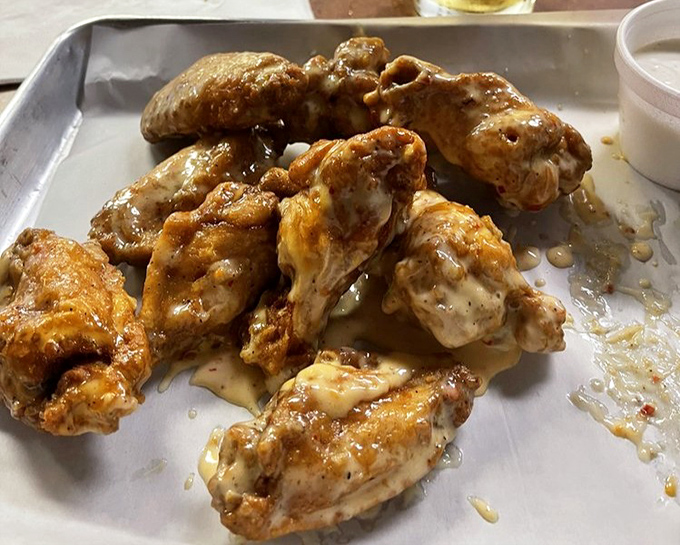 These wings, glistening with sauce, aren't just food—they're a reason to schedule your next visit before you've even finished this one.