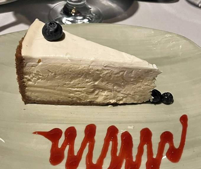 A slice of cheesecake that understands the importance of simplicity—creamy, rich, and adorned with just enough berries to count as "fruit."