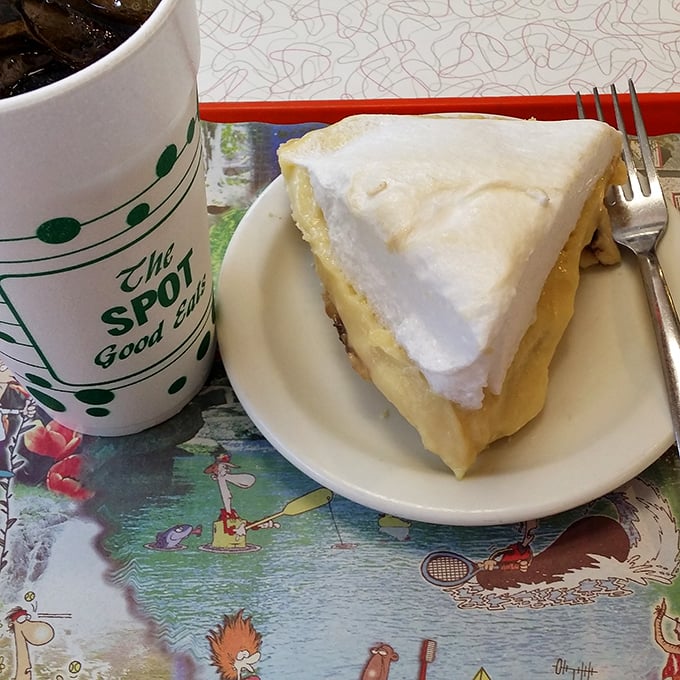 A slice of coconut cream pie with mile-high meringue sits beside a branded mug—the perfect finale to a meal that feels like coming home.