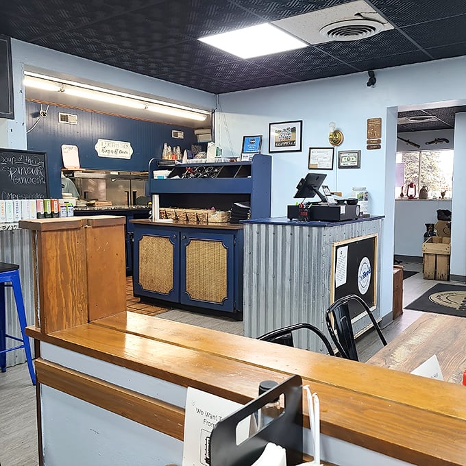 The heart of operations—where orders become meals and hungry visitors become satisfied regulars. Blue and wood create the perfect backdrop.