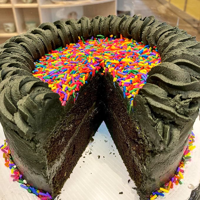 A chocolate cake ringed with rainbow sprinkles – proof that sometimes the most serious desserts wear the most playful accessories.