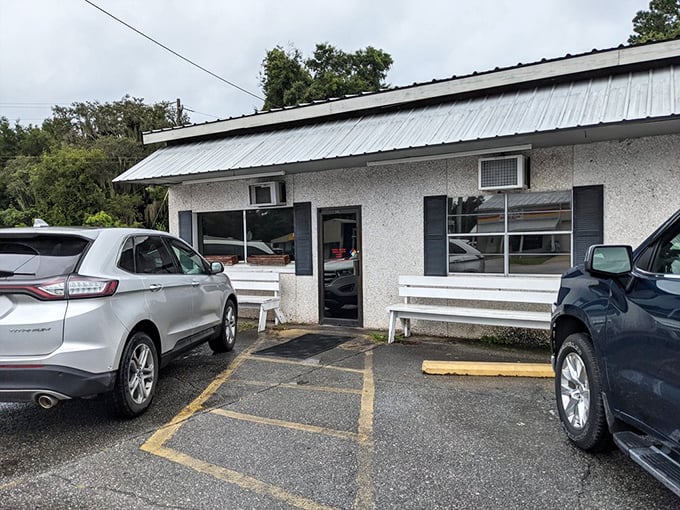 The entrance might not scream "culinary destination," but those white benches have held generations of satisfied diners catching their breath after epic meals.