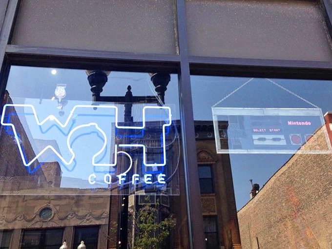 The window's neon Nintendo controller and "WH COFFEE" sign glow like a beacon for caffeine-seeking gamers. Press START to continue your day.