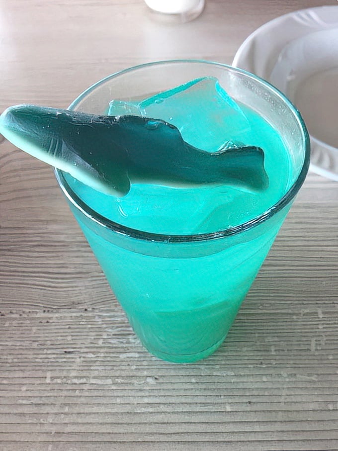 The blue drink that launched a thousand Instagram posts—complete with shark garnish that's more charming than threatening.
