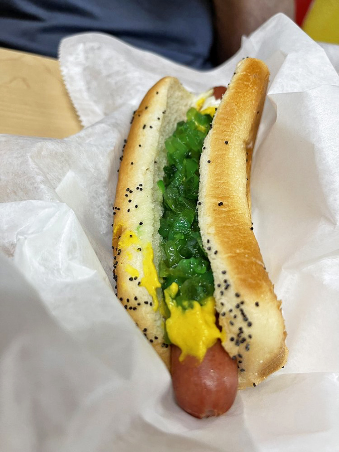 A Chicago dog in progress—the neon green relish and yellow mustard creating a color palette that screams "this ain't no ordinary hot dog."