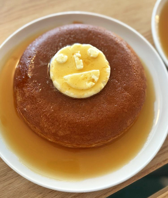 That pancake isn't just smiling at you—it's practically winking, floating in a maple syrup pool that's basically breakfast nirvana on a plate.