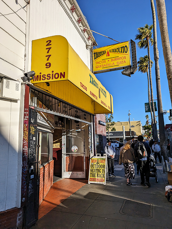 The sidewalk scene—where the anticipation of what's inside that yellow awning makes even the wait feel like part of the experience.