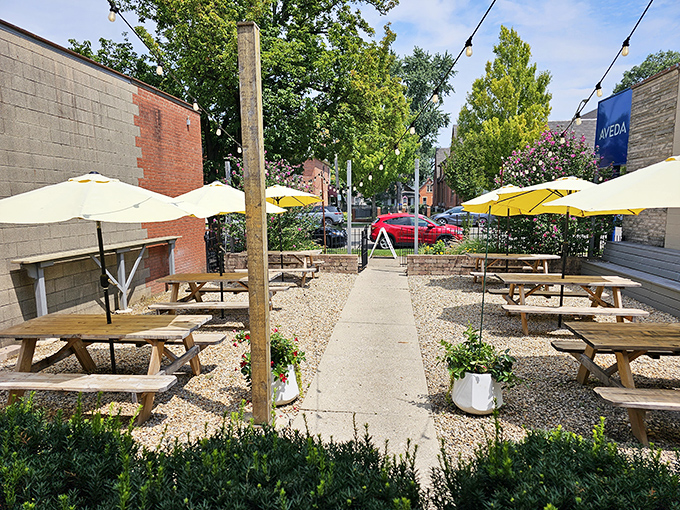 The outdoor dining area—where string lights, yellow umbrellas, and picnic tables create the perfect stage for your personal meat festival.