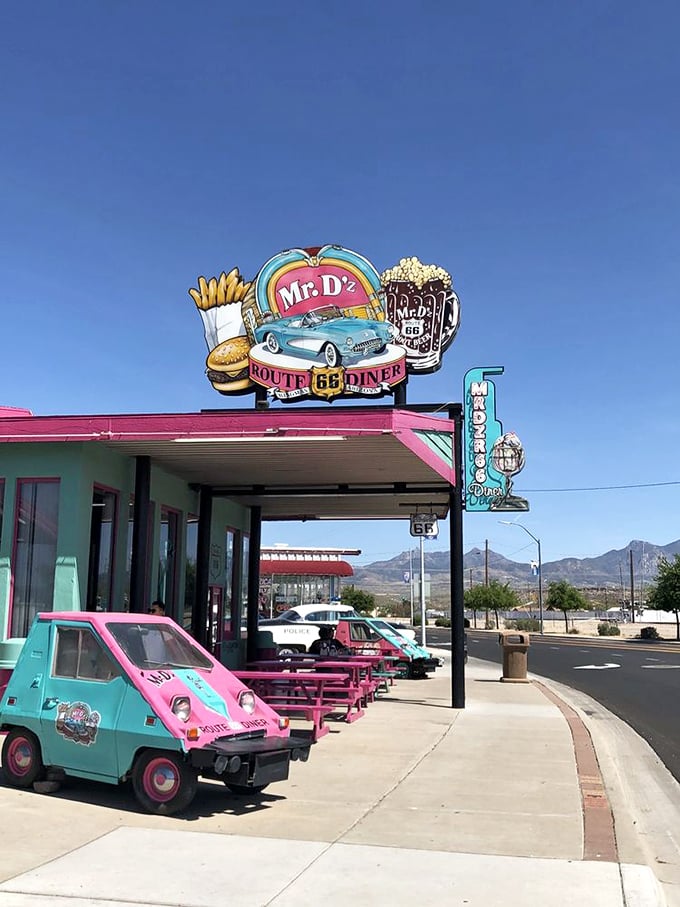 That sign isn't just advertising—it's a beacon of hope for hungry travelers. The tiny turquoise car below seems to say, "Yes, we're quirky and proud of it!"