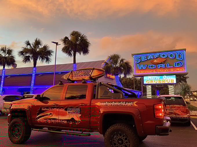 When the sun sets, Seafood World transforms into a neon-lit beacon for hungry travelers. That truck isn't delivering—it's advertising mobile seafood dreams.