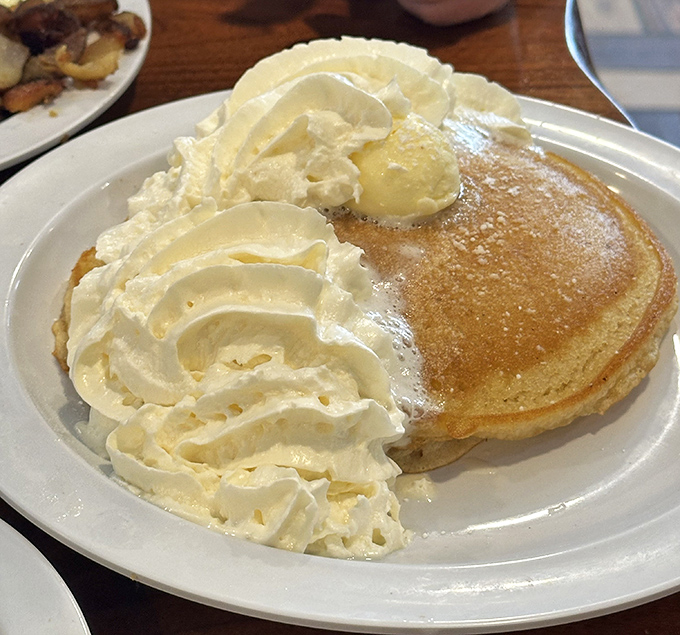 A pancake crowned with whipped cream and butter—the breakfast equivalent of pulling up to a red carpet in a limousine.