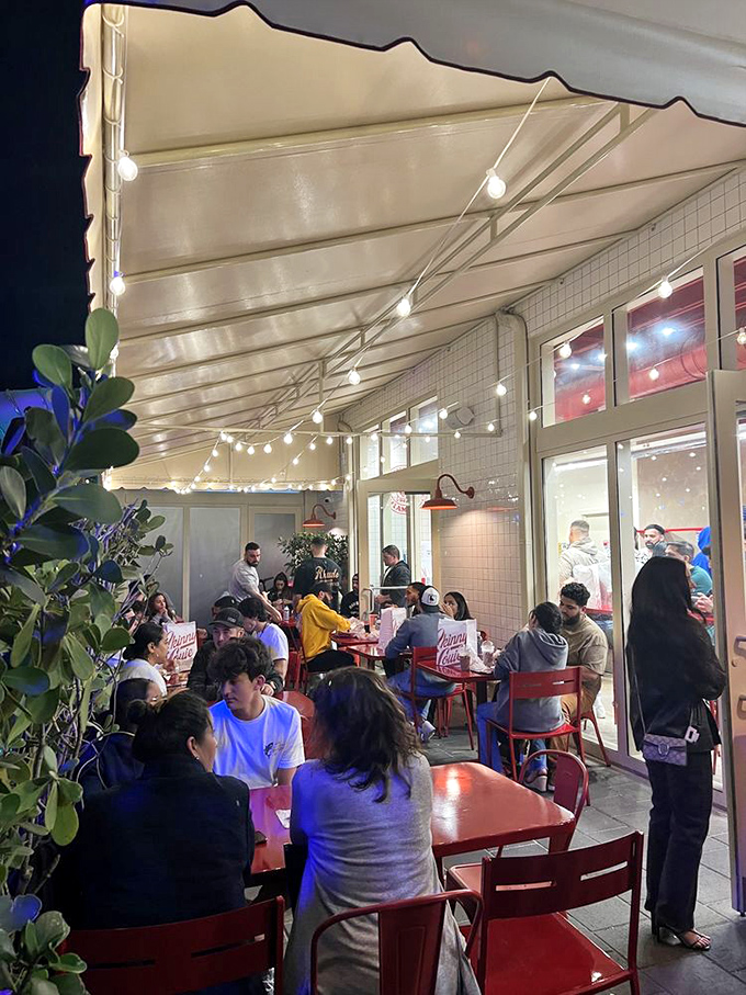 String lights, red tables, and happy diners under the Miami sky—the patio scene at Skinny Louie feels like a burger block party.