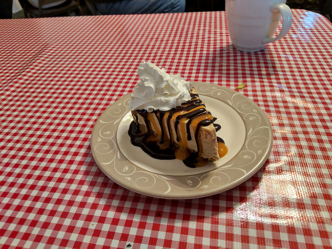 A slice of heaven drizzled with chocolate and caramel, topped with whipped cream—proof that dessert is not just a course, but a necessity.