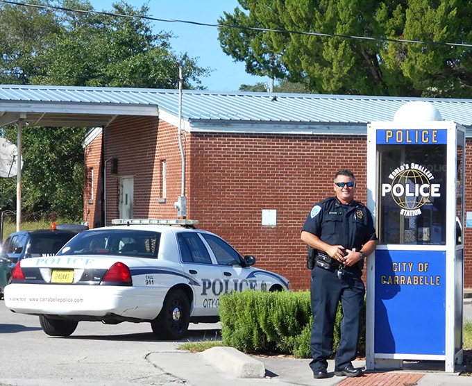 A real police officer demonstrates that this phone booth actually serves as functional law enforcement headquarters.