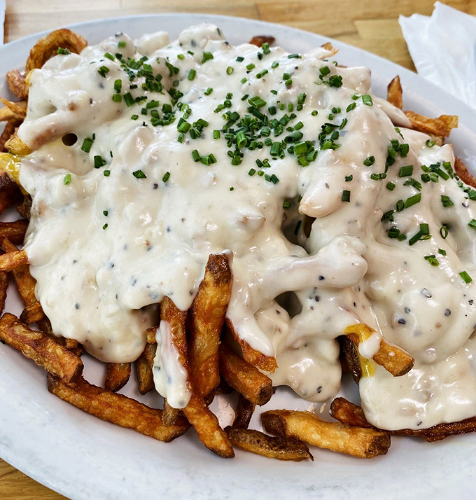 Crispy fries swimming in gravy and sprinkled with chives – proof that sometimes the messiest foods are the ones most worth the napkin investment.