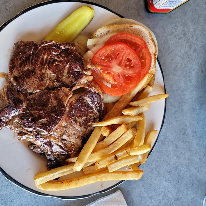 A steak sandwich that doesn't mess around—serious meat for serious appetites, with fries standing at attention alongside like loyal soldiers.