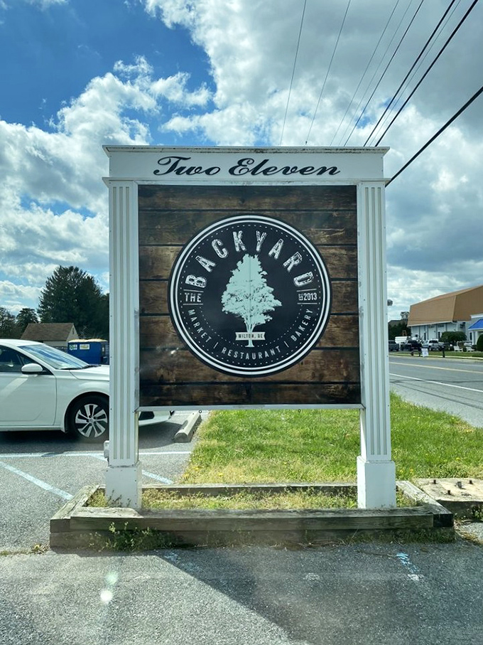 The roadside sign announces your arrival at The Backyard with understated confidence—like it knows you'll be back before the week is out.