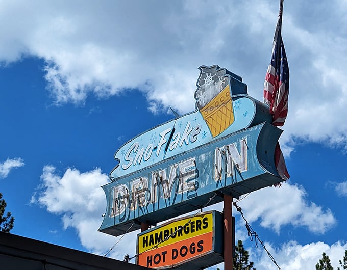That vintage neon sign against a perfect blue sky—a beacon of hope for the hungry traveler and a promise of deliciousness to come.