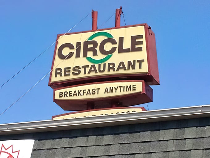 The sign proudly announces "BREAKFAST ANYTIME" against the blue sky—three syllables that sound remarkably like "I love you" to hungry travelers.