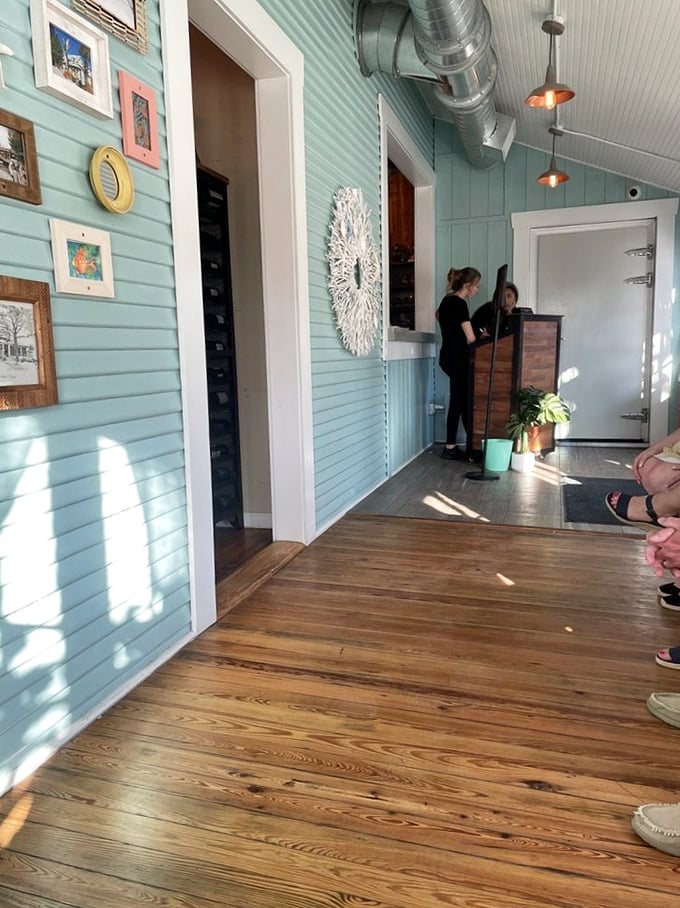 The entryway's dappled sunlight creates the perfect transition from real world to restaurant reality. Those wooden floors have stories.