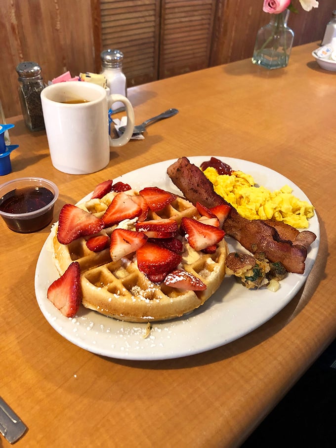 A waffle that's found its soulmate in fresh strawberries. That dusting of powdered sugar is like nature's way of saying "you've made the right choice."