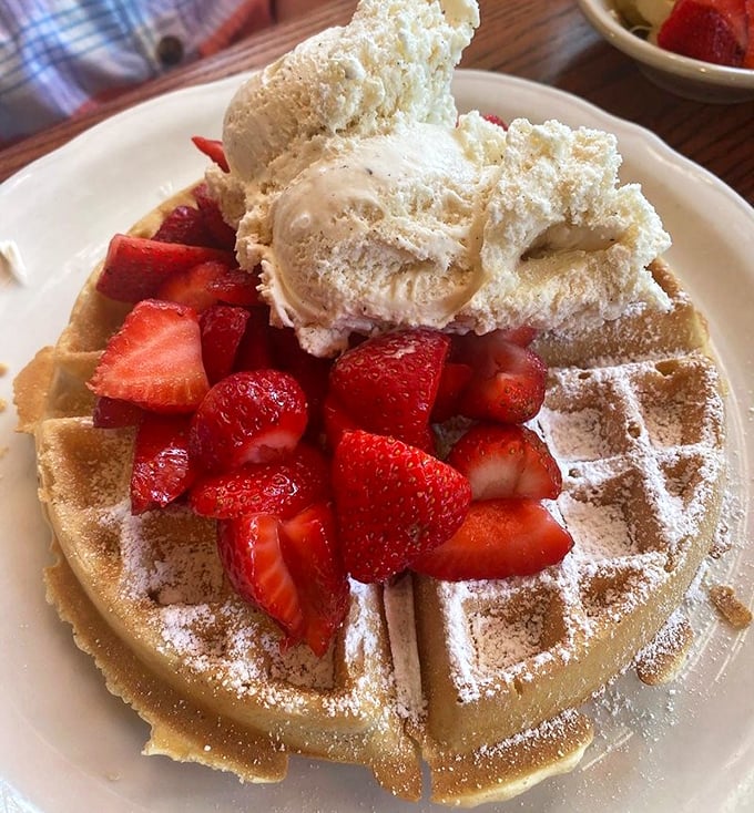 A Belgian waffle crowned with strawberries and ice cream—because sometimes breakfast should feel like you're getting away with something.