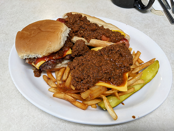 The holy trinity of diner perfection: a burger smothered in meat sauce, cheese fries that don't apologize for being indulgent, and a pickle for "balance."
