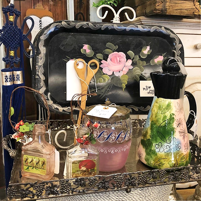A hand-painted tray surrounded by vintage glassware—the kind of collection that starts with "just one piece" and somehow becomes your personality.