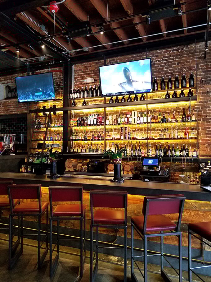 A bar that takes its bourbon seriously, with bottles glowing like amber treasures. This isn't just a drink selection—it's a whiskey library waiting to be explored.