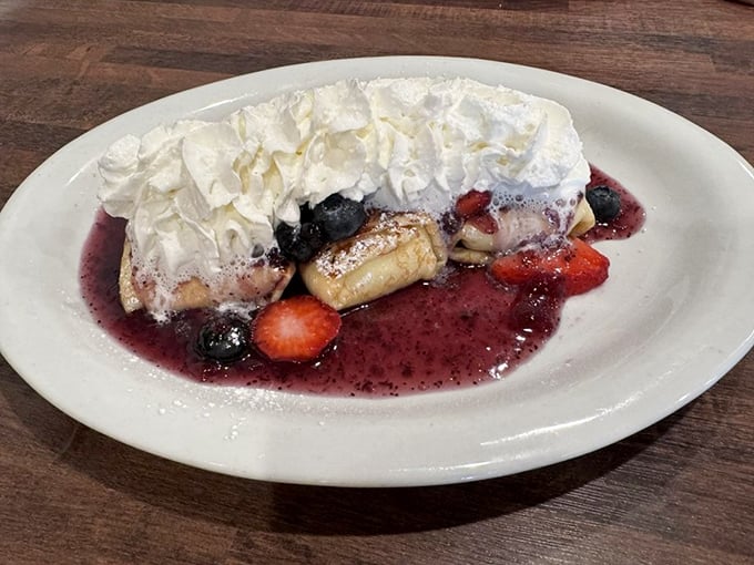 This berry-topped blintz with its mountain of whipped cream isn't just dessert masquerading as breakfast—it's breakfast elevated to art form.