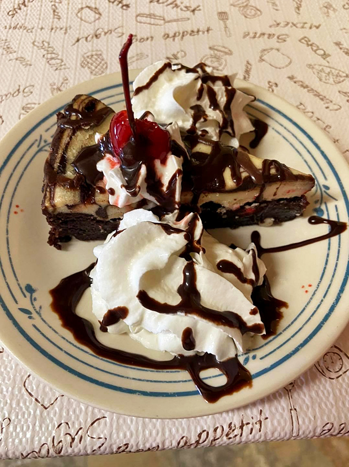 Chocolate cheesecake drizzled with sauce and crowned with whipped cream and a cherry—dessert that doesn't just end a meal, but makes it legendary.