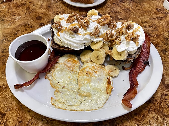 French toast that's having an identity crisis as a dessert, complete with whipped cream, bananas, and walnuts. Breakfast or dessert? Yes, please.