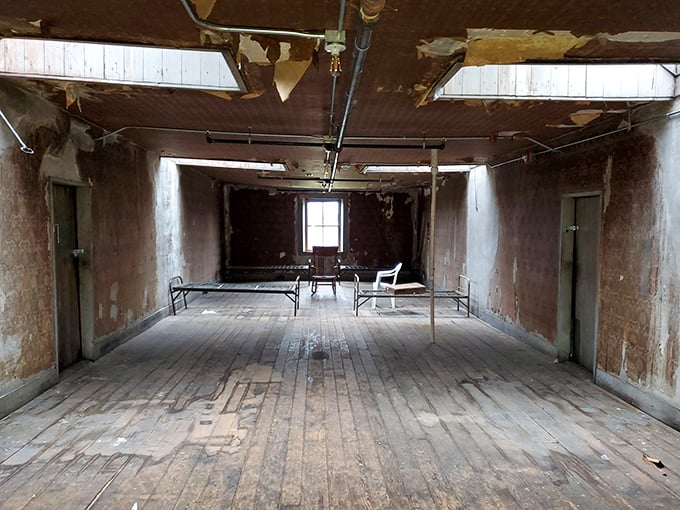 Institutional minimalism at its most haunting—bare walls, simple beds, and the lingering question of how many souls called this sparse room home.