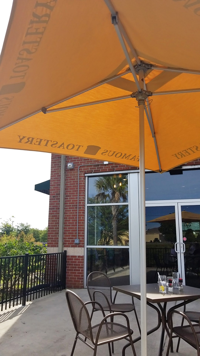 Outdoor seating under Famous Toastery's signature orange umbrellas—where breakfast meets fresh air and palm trees provide the perfect Carolina backdrop.