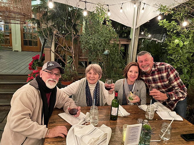 Happy diners raising glasses in the outdoor garden—because the only thing better than amazing food is sharing it with good company.