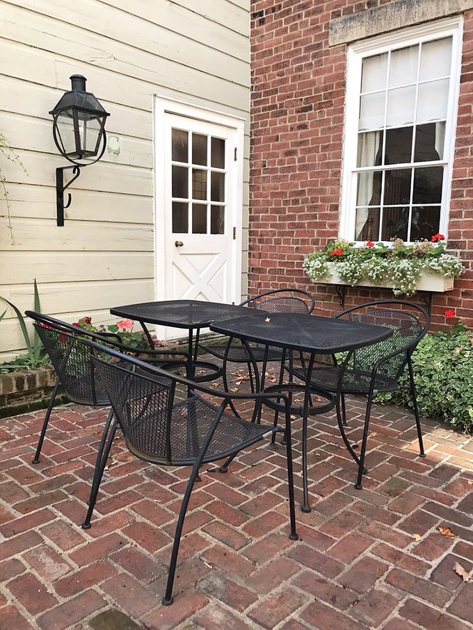 The courtyard seating area offers fresh air with a side of historical ambiance. Those brick pavers have more stories than a library—and they're serving them with your appetizers.