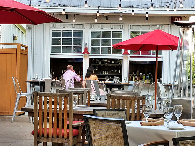 Red umbrellas add pops of color to the outdoor dining area—a perfect setting for those summer evenings when eating indoors seems criminal.